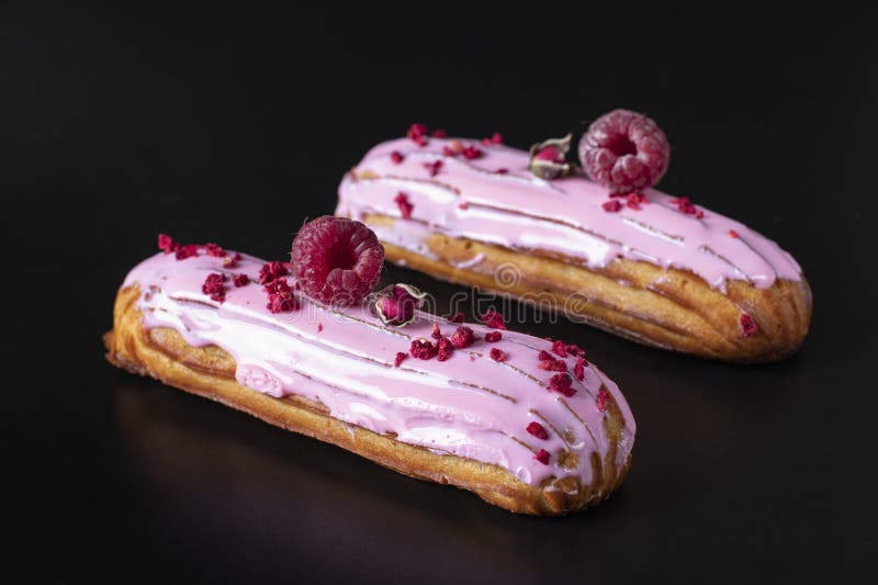 Berry Eclairs Covered with Pink Icing and Decorated with Raspberries on ...
