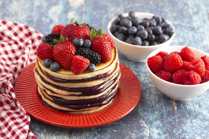 Berry Pancakes with Compote Spread on a Rustic Blue Wood Table Stock ...