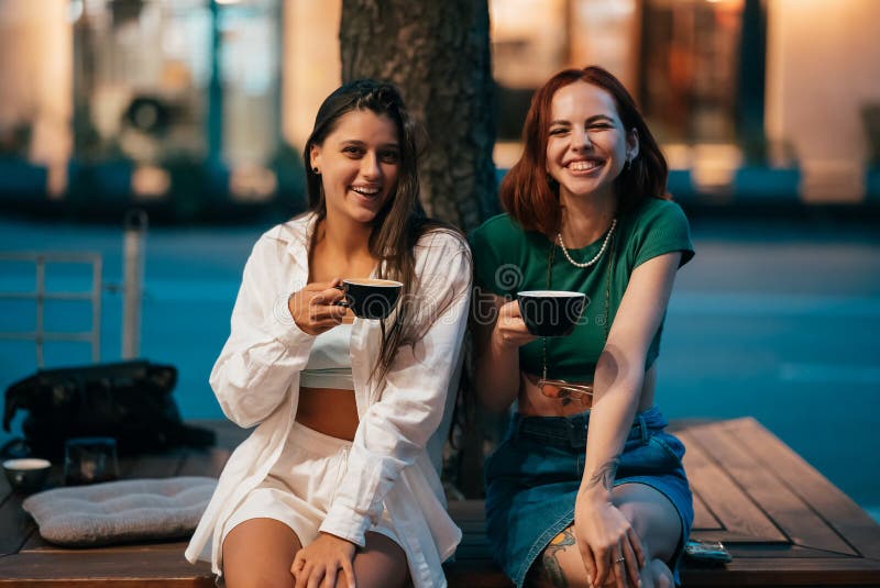 Best Friends Sitting on the Park Bench Drinking Coffee. Stock Image ...
