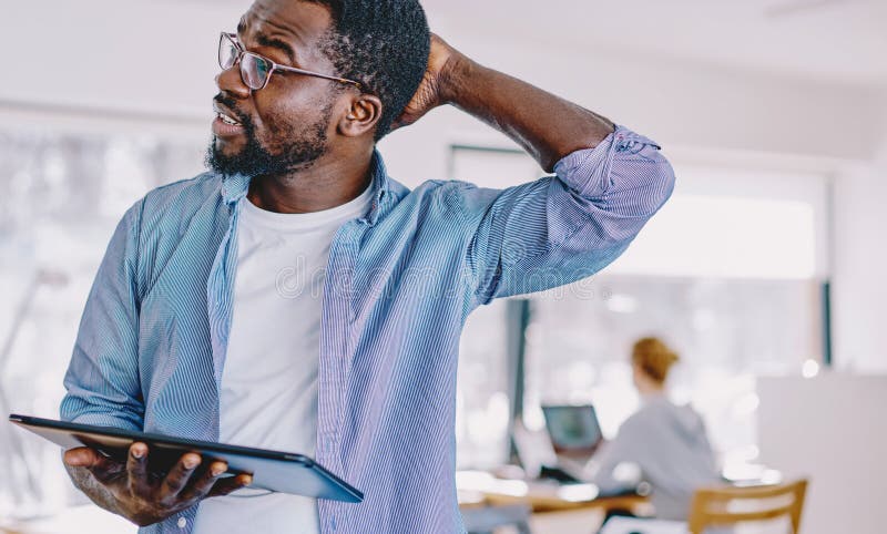 Bewildered Ethnic Guy with Tablet in Office Stock Photo - Image of ...