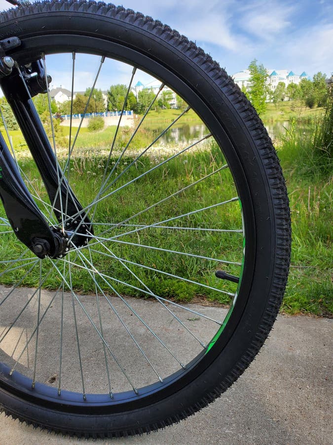A Bicycle Front Tire and Green Grass at Back Stock Image - Image of ...