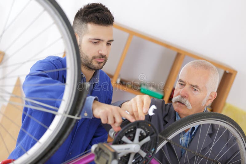 Bicycle Mechanic and Apprentice Repairing Bike in Workshop Stock Image ...