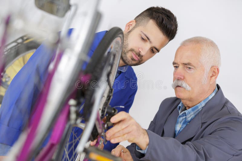 Bicycle Mechanic and Apprentice Repairing Bike in Workshop Stock Image ...