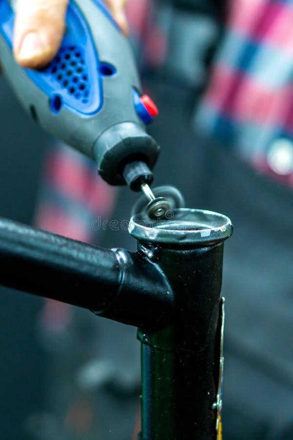 A Bicycle Mechanic Has a Grinding Tool in His Hands. the Mechanic Uses ...