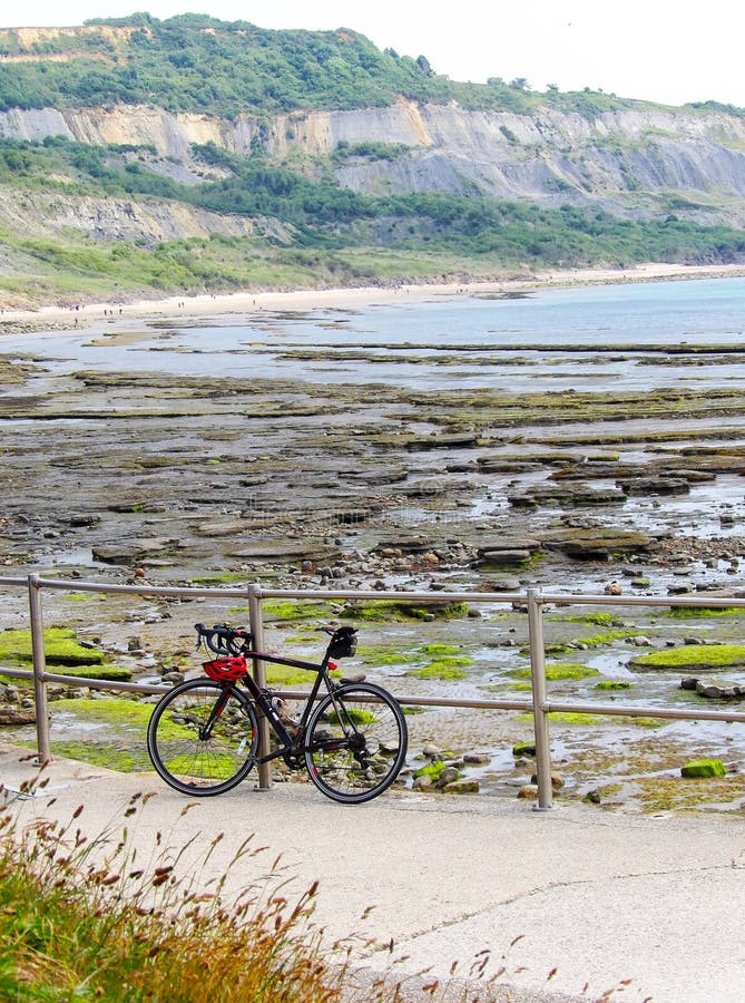 Bicycle at Rest on Railing by Ocean and Mountian Backdrop Stock Photo ...