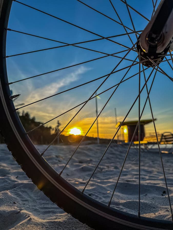 Bicycle Wheel Close-up on Sandy Beach at Sunset, Capturing Evening ...
