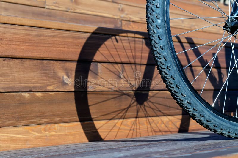 Bicycle Wheel with Shadow from Wheel on Wooden Boards Stock Photo ...