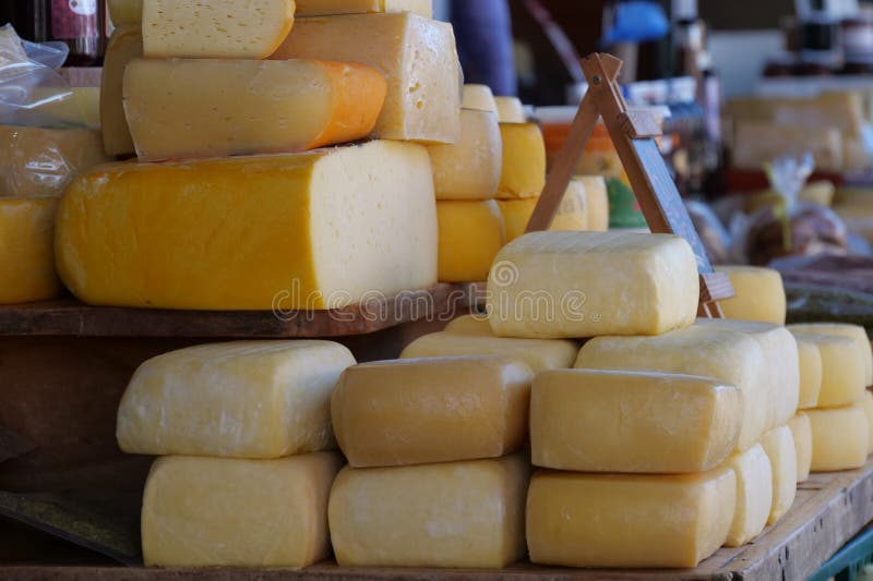 Big Blocks of Cheese Stacked on a Table in a Market Stock Photo - Image ...