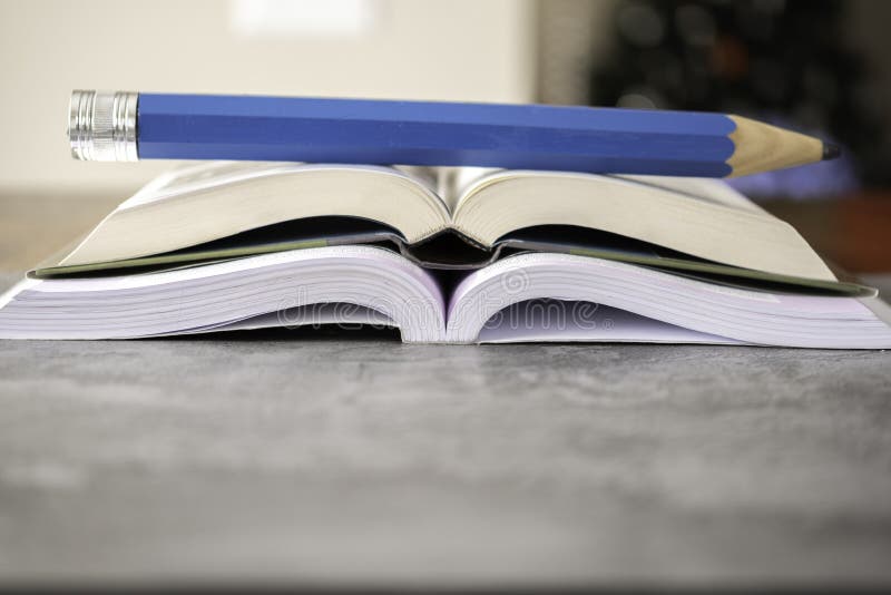 Big Blue Pencil on a Pile of Open Books Stock Image - Image of design ...