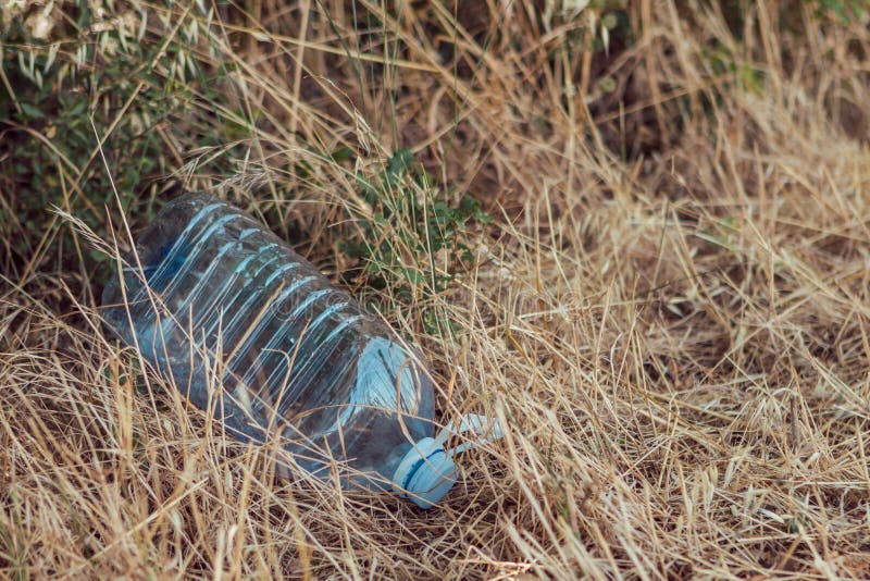 Big Bottle of Water among the Grass in the Field. Environment Plastic ...