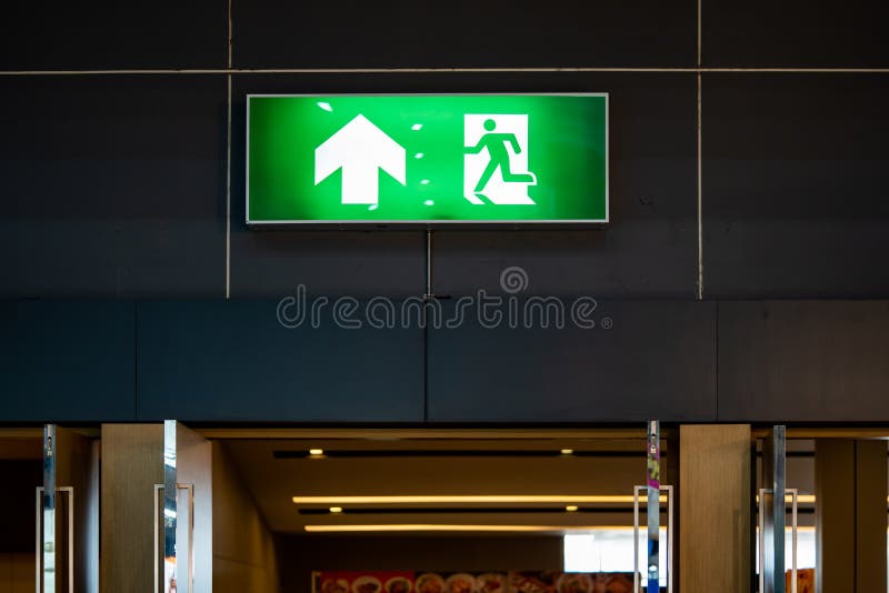 Big Emergency Fire Exit Sign is Placed on the Black Wall Over the Door ...