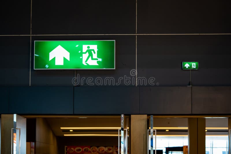 Big Emergency Fire Exit Sign is Placed on the Black Wall Over the Door ...