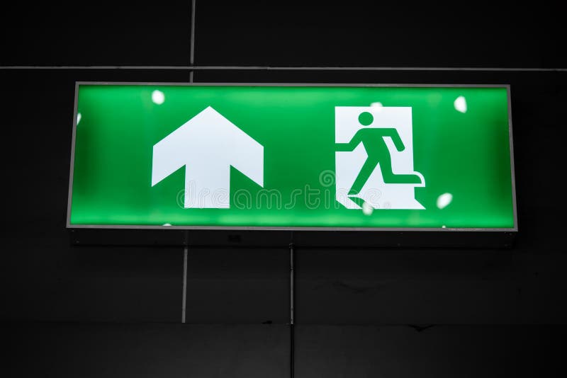 Big Emergency Fire Exit Sign is Placed on the Black Wall Over the Door ...