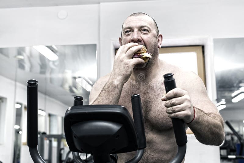 A Big Fat Hungry Man Eats a Hamburger with Meat and Cheese Stock Photo ...
