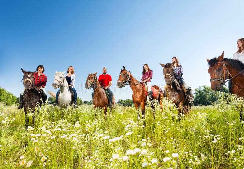 Big Group of Horseback Riders in Flowery Meadow Stock Photo - Image of ...