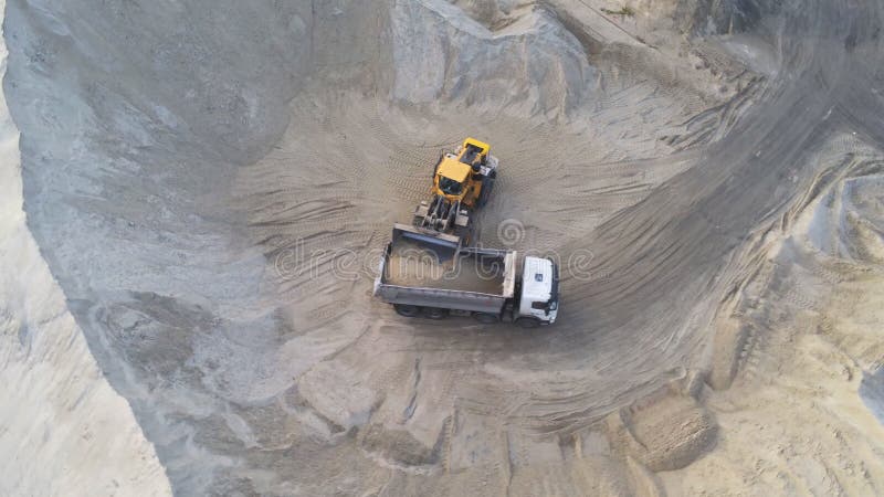 Big Heavy Wheel Loader Loading Sand into Dump Truck in Sand Pit. Heavy ...