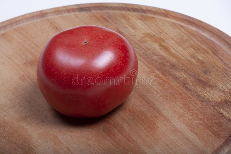 Big Red Tomato on a Round Wooden Board Stock Photo - Image of white ...