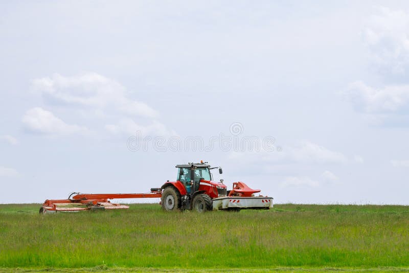 Big Red Tractor with Two Mowers Mows the Grass for Silage Stock Photo ...