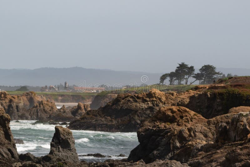 Big Rocks and Cliffs at Glass Beach California with a Mountain in the ...