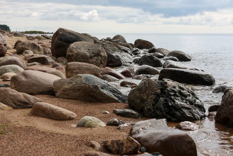 Big rocks on a sandy beach stock photo. Image of water - 180958836