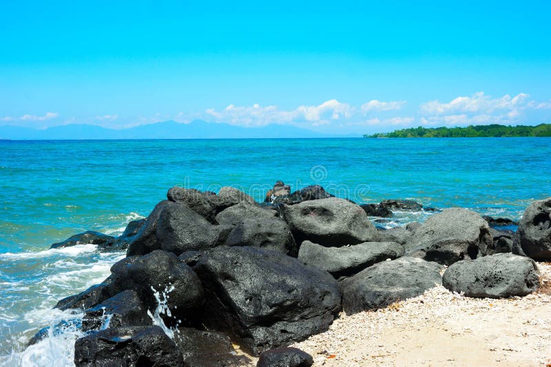 Rocks on the Shore of a Beautiful Beach with Blue Water Stock Image ...