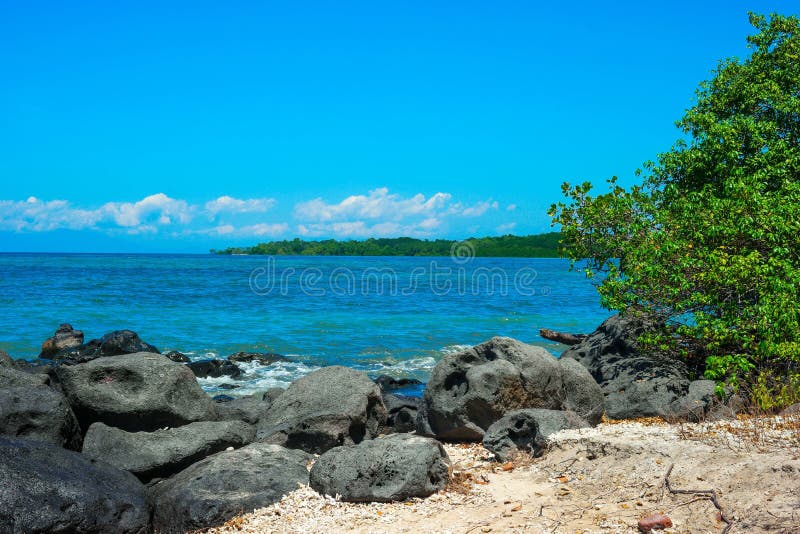 Rocks on the Shore of a Beautiful Beach with Blue Water Stock Image ...