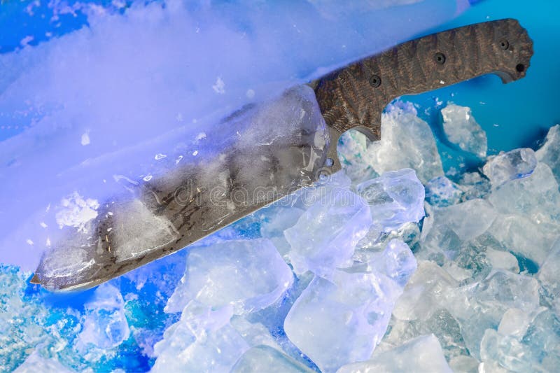 Big Sharp Knife Lying Down among Ice Cubes, Pieces on Blue Background ...