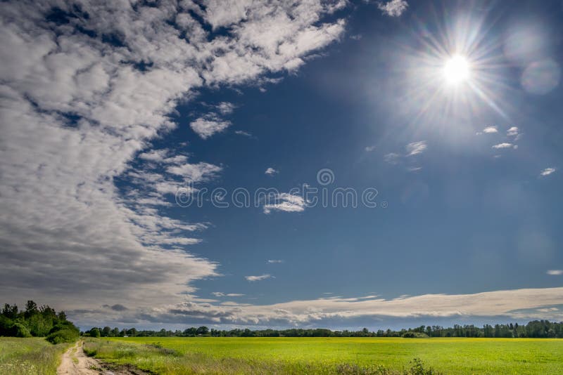 A Big Sky Over a Green Field with Sun Rays Stock Photo - Image of ...