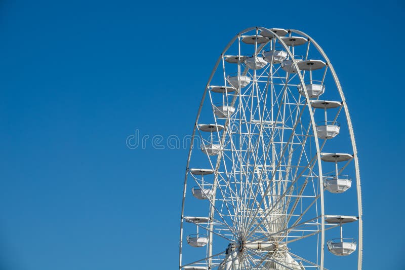 White Ferris Wheel with Glass Light Blue Cabins Against Blue Sky, Dubai ...