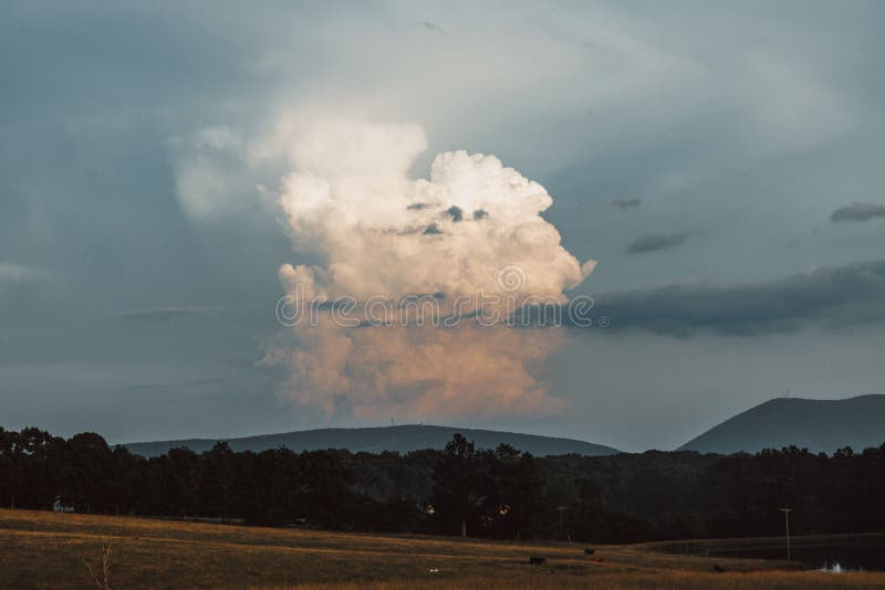 Big White Cloud in a Gloomy Stormy Sky Over Mountains and Fields with ...
