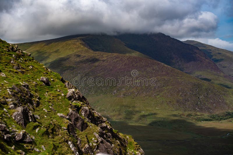 A Big White Cloud Stuck on the Top of a Mountain Stock Photo - Image of ...