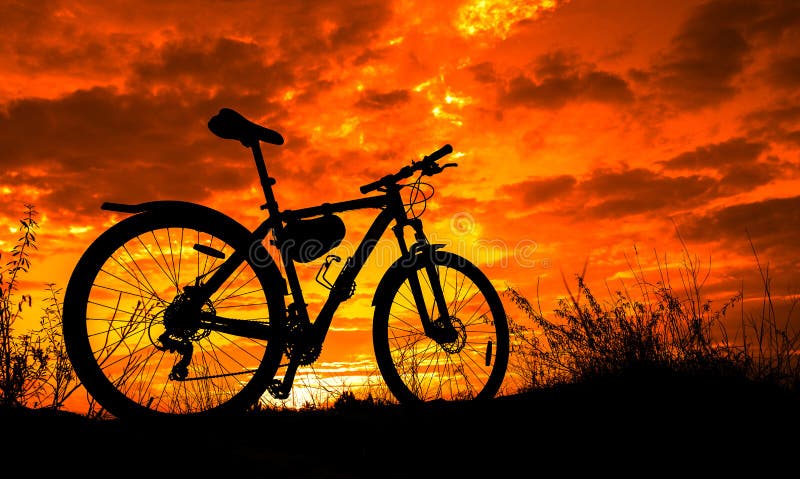 Cyclist With A Bicycle, In The Background Fiery Sunset Stock Photo ...