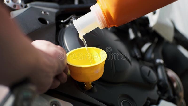 Biker Change Engine Oil on Motorcycle. Pouring Oil To Motorcycle Engine ...
