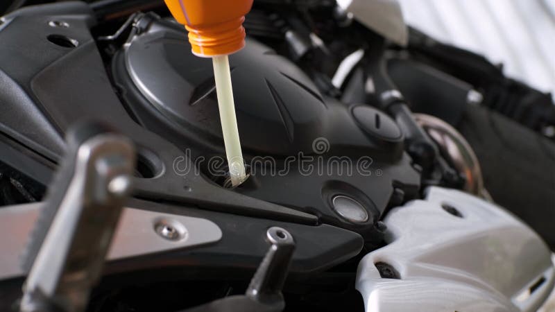 Biker Change Engine Oil on Motorcycle. Pouring Oil To Motorcycle Engine ...