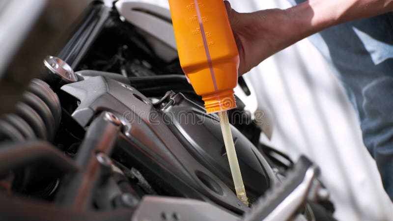 Biker Change Engine Oil on Motorcycle. Pouring Oil To Motorcycle Engine ...