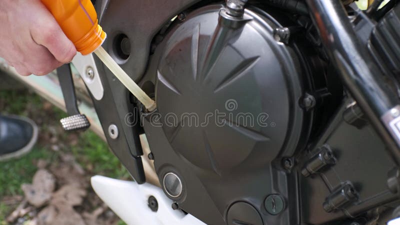 Biker Change Engine Oil on Motorcycle. Pouring Oil To Motorcycle Engine ...