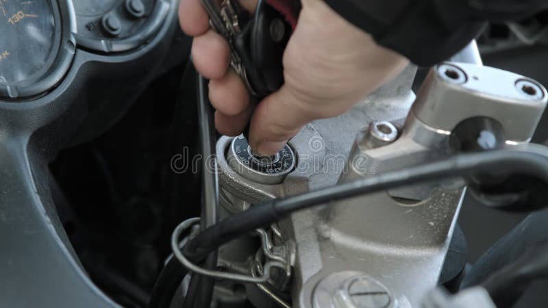 Biker Hand Inserts the Key into Ignition of the Motorcycle, Turns it on ...