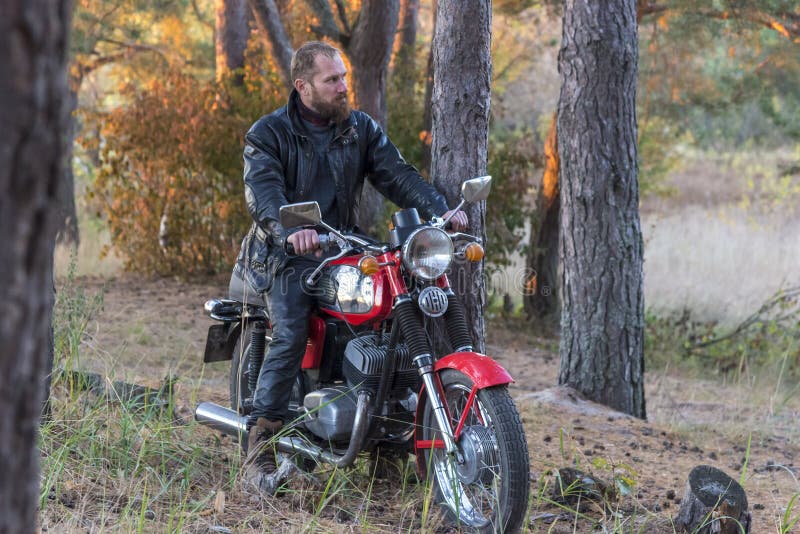 Biker in a Leather Jacket and Helmet on a Retro Motorcycle in the ...