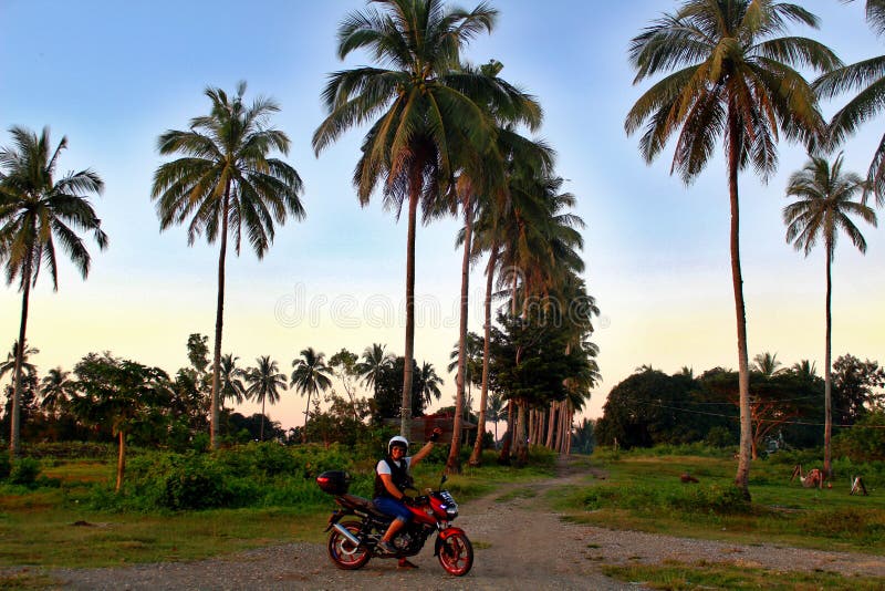 Biker with Raised Hand on a Background of Sunset in the Tropics Stock ...