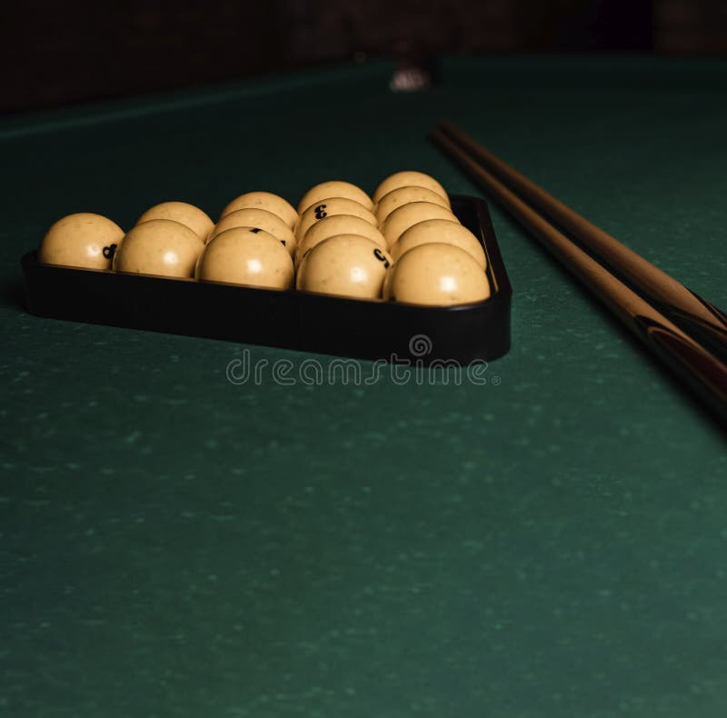 Billiard Cues and Pyramid of Yellow Pool Balls on Green Billiard Table ...