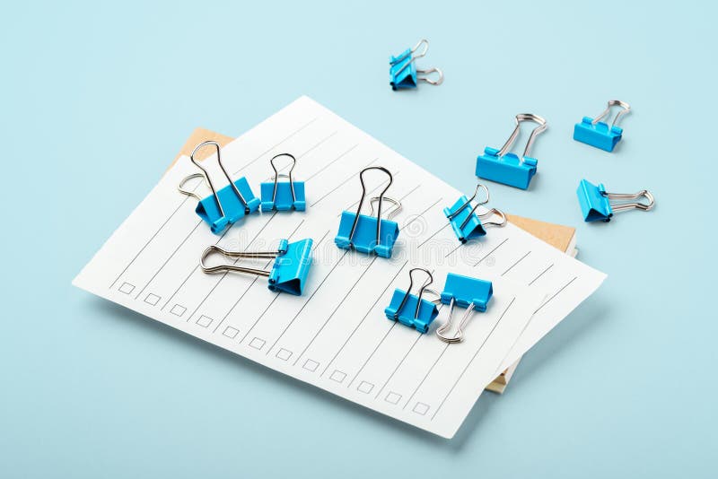 Binder Clips on Checklist Paper on Light Blue Background Stock Image ...