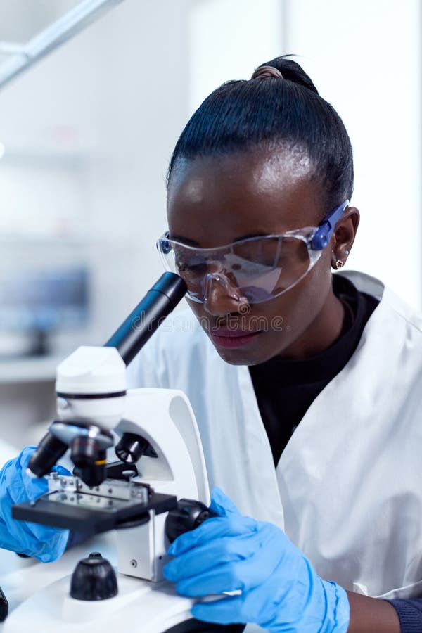 Biochemistry Technician with African Ethnicity Using Microscope Stock ...