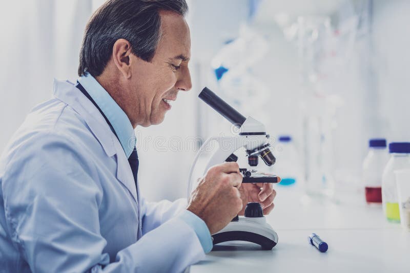 Bioengineer Wearing White Uniform Looking into Microscope Stock Photo ...