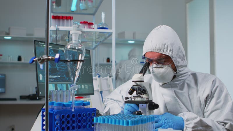 Biologist Doctor in Coverall Checking DNA Sample Using Microscope Stock ...
