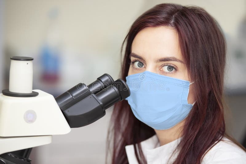 Biologist in a Medical Mask with a Microscope Stock Image - Image of ...