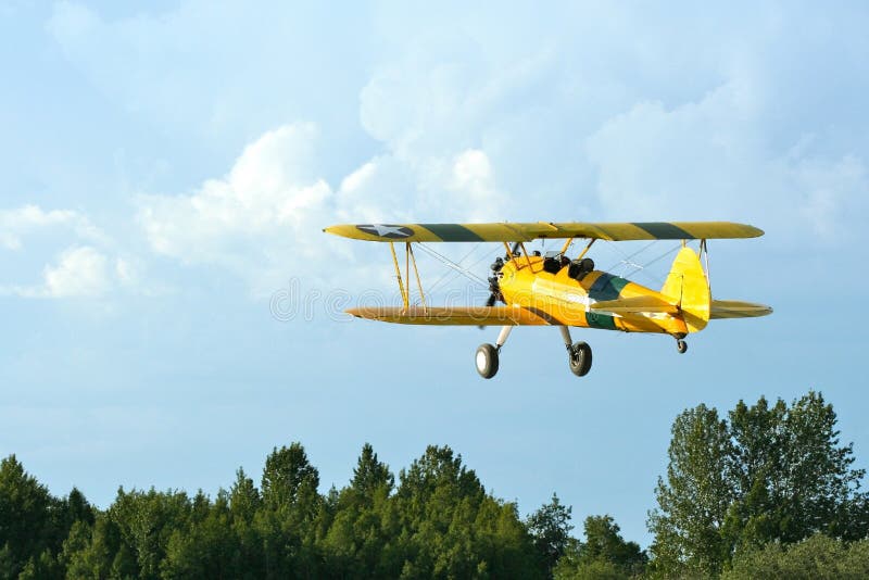 Yellow biplane over trees stock photo. Image of army, pilot - 9452788