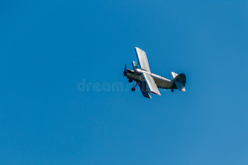 Biplane flying in blue sky stock image. Image of blue - 187619263