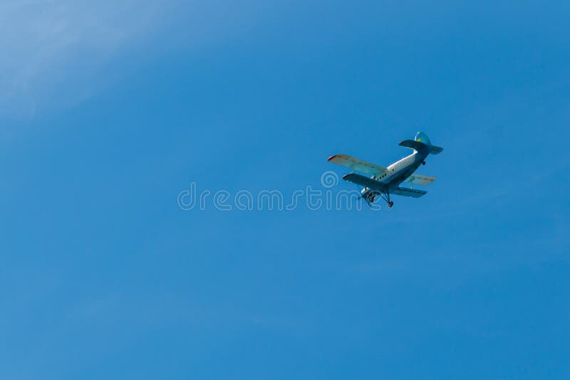 Biplane flying in blue sky stock image. Image of blue - 187619263