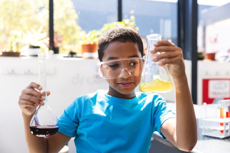 Biracial Boy Examines Science Experiment at School in the Classroom ...