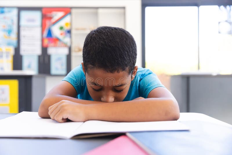Biracial Boy Focused on Reading a Book in the Classroom at School Stock ...